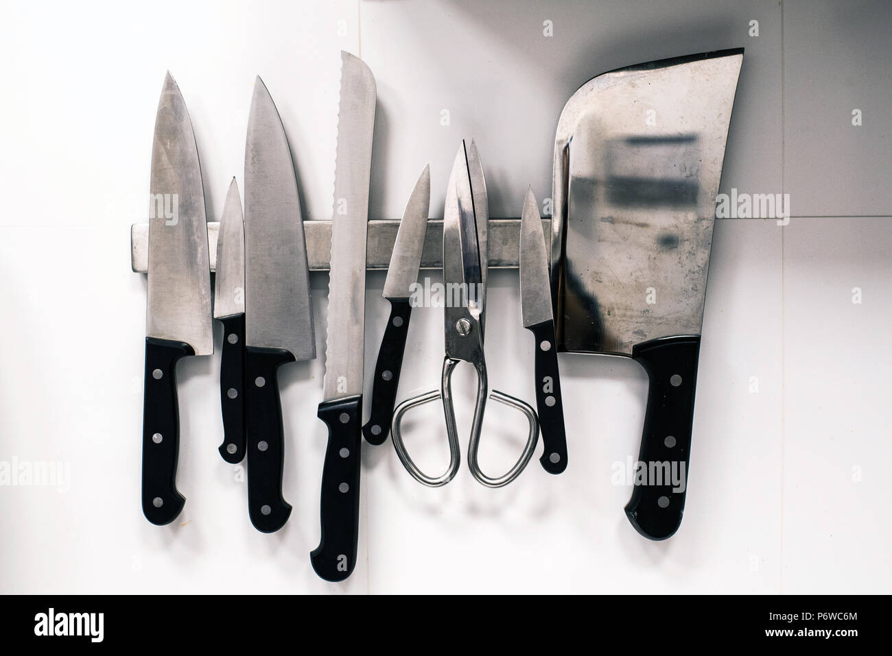 Professional steel knives hanging in a kitchen Stock Photo - Alamy