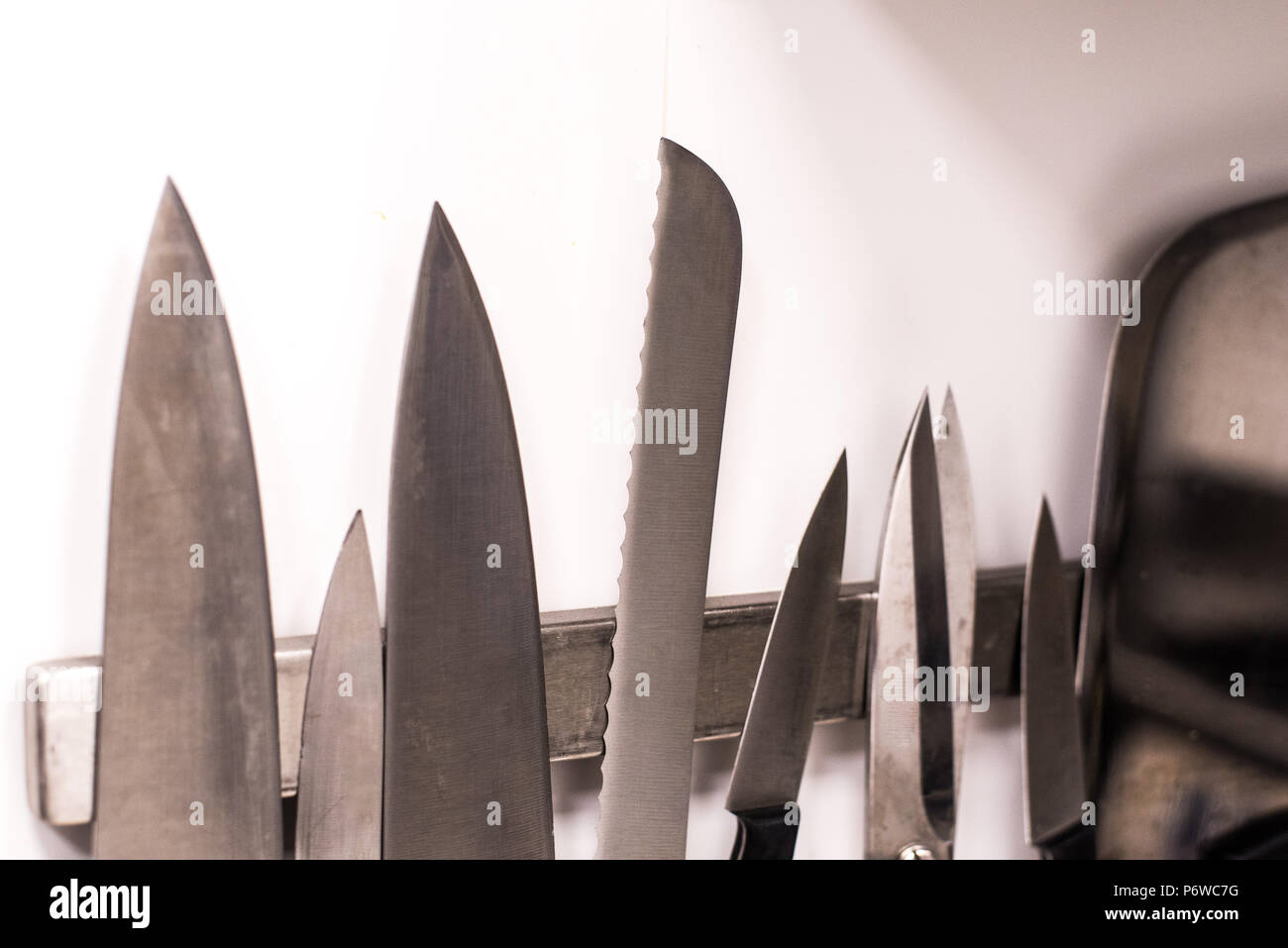Professional steel knives hanging in a kitchen Stock Photo - Alamy