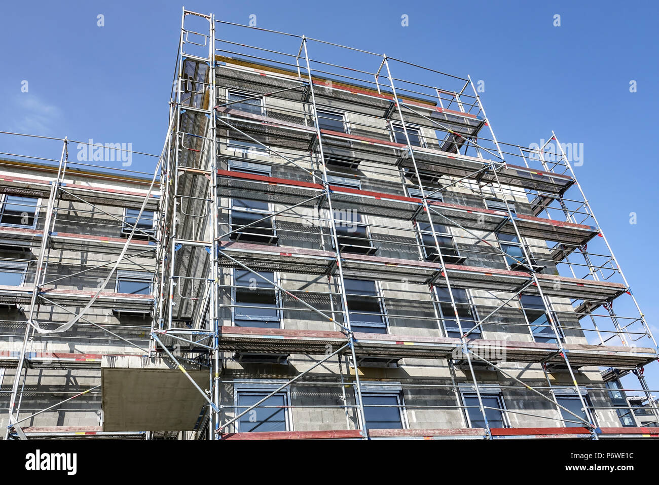 Front of a high-rise building covered in scaffolding in a concept of ...
