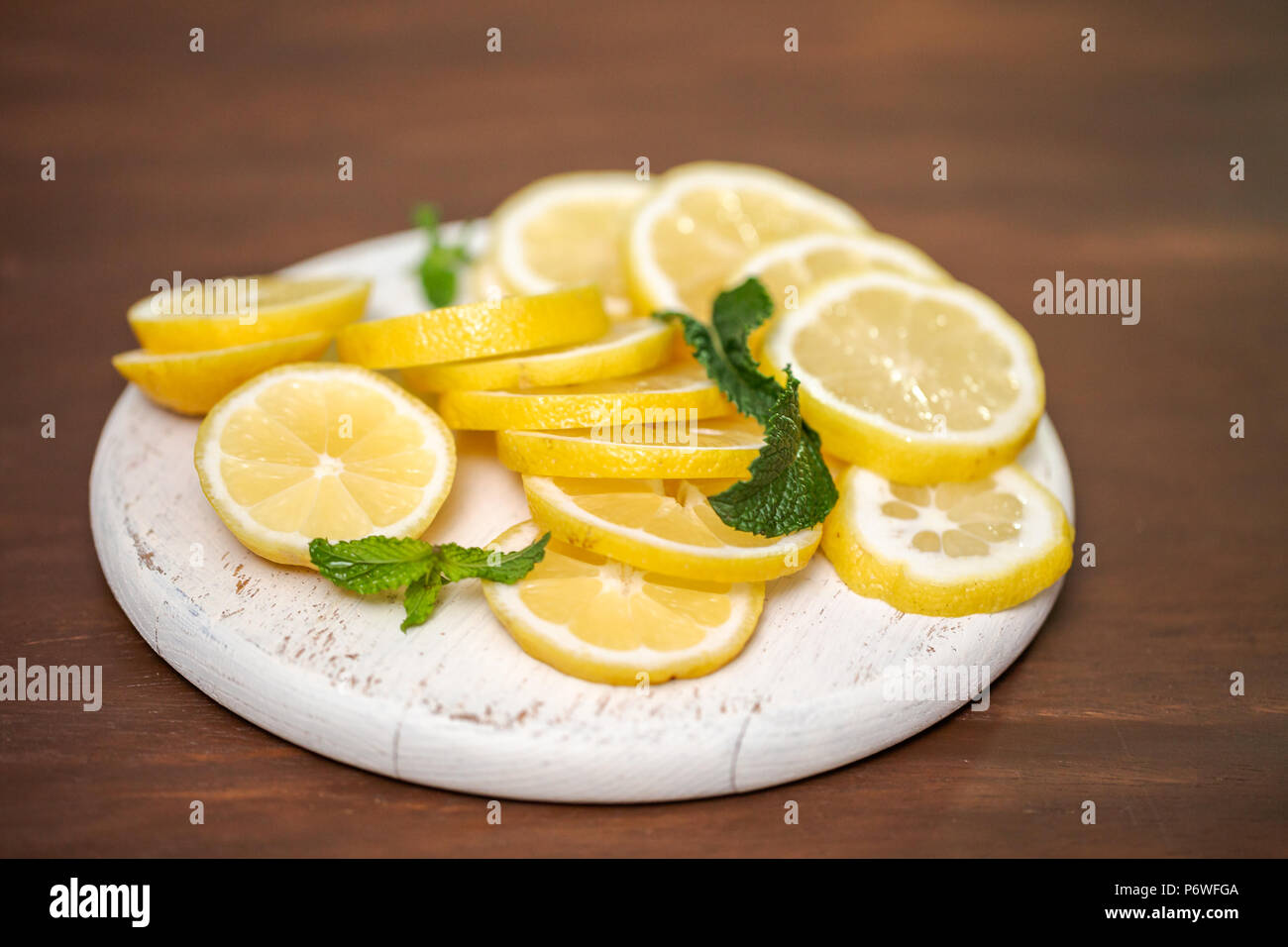 Fresh sliced lemon on a white wood cutting board Stock Photo - Alamy