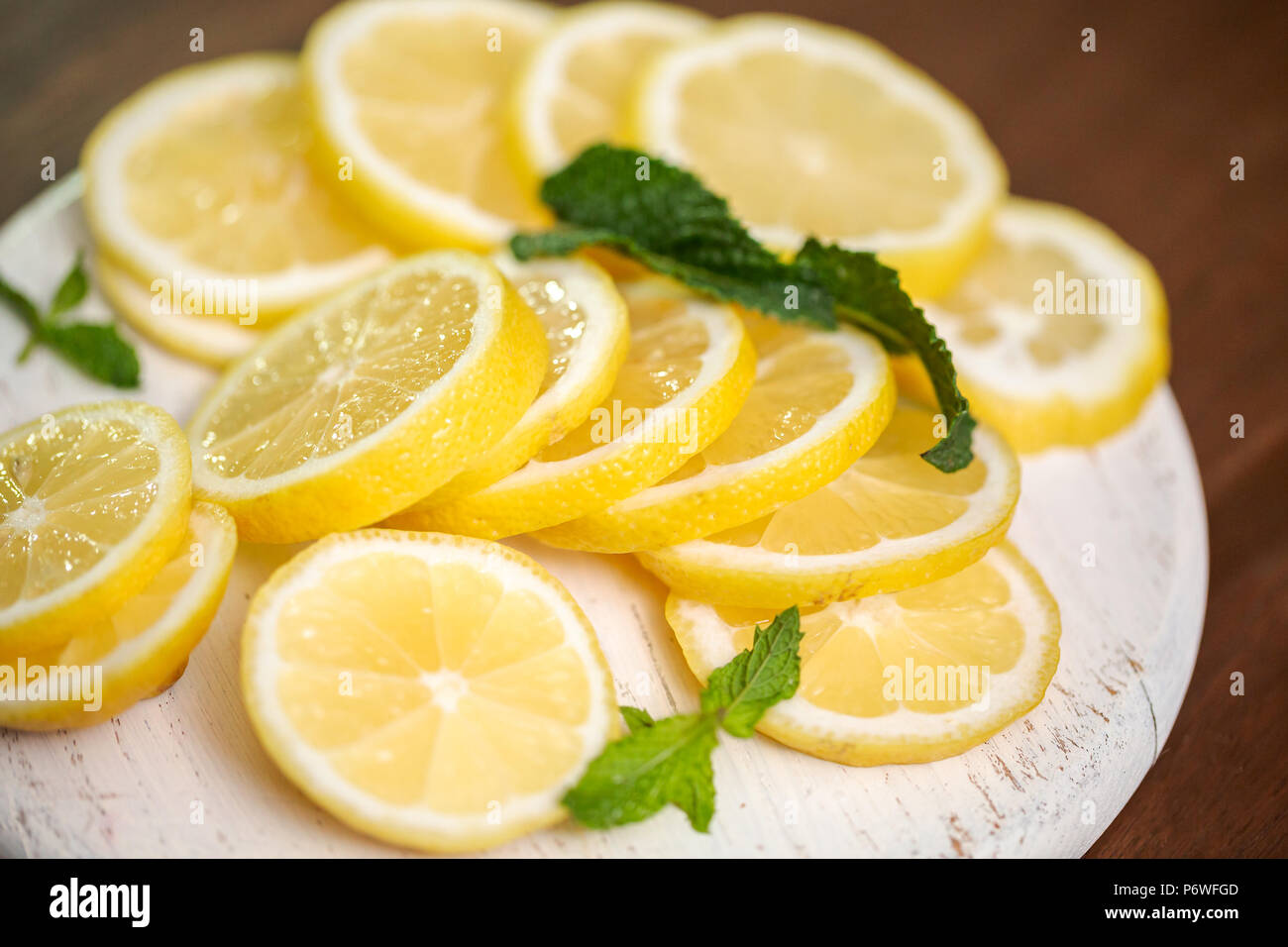 Fresh sliced lemon on a white wood cutting board Stock Photo - Alamy