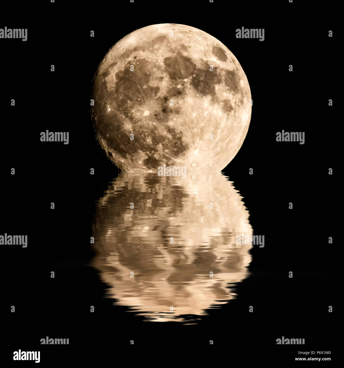 Extreme close-up of a moonrise above horizon. The full moon reflects in ...