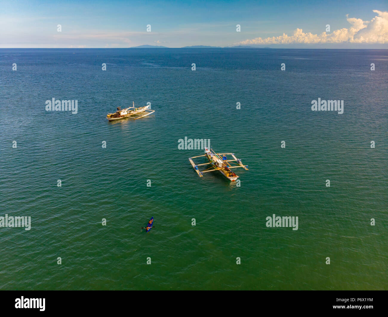 Aerial view of boats and a tourist swimming beyond the resort's ...