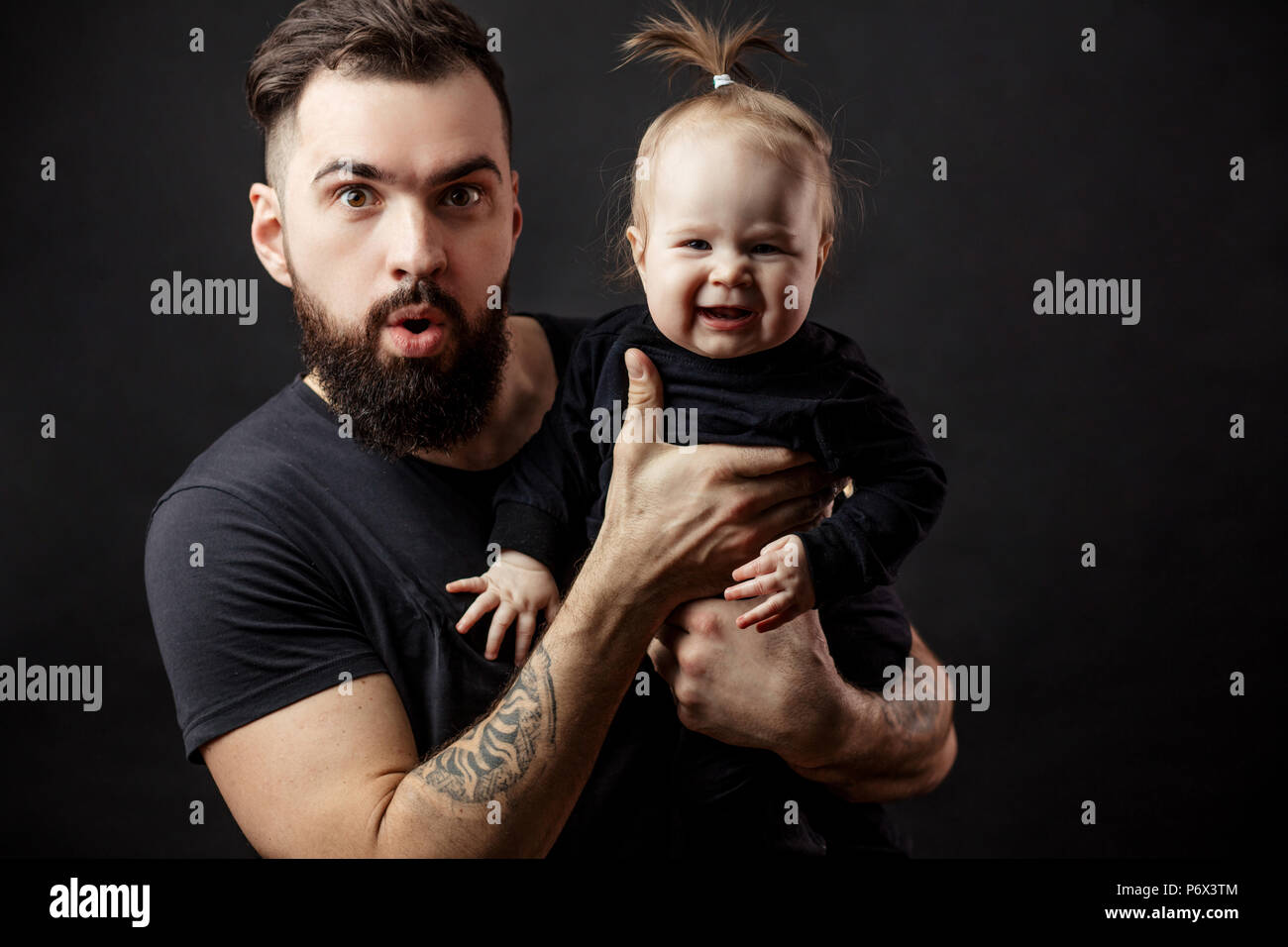 surprised young man with baby on black Stock Photo - Alamy