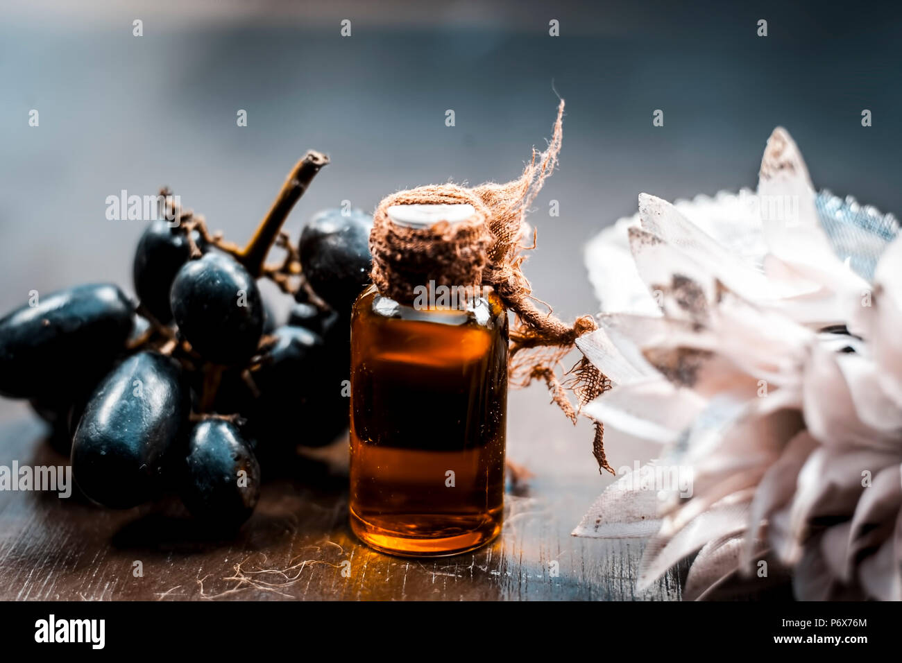 Close up of Black grapes oil on a wooden surface in dark Gothic colors ...