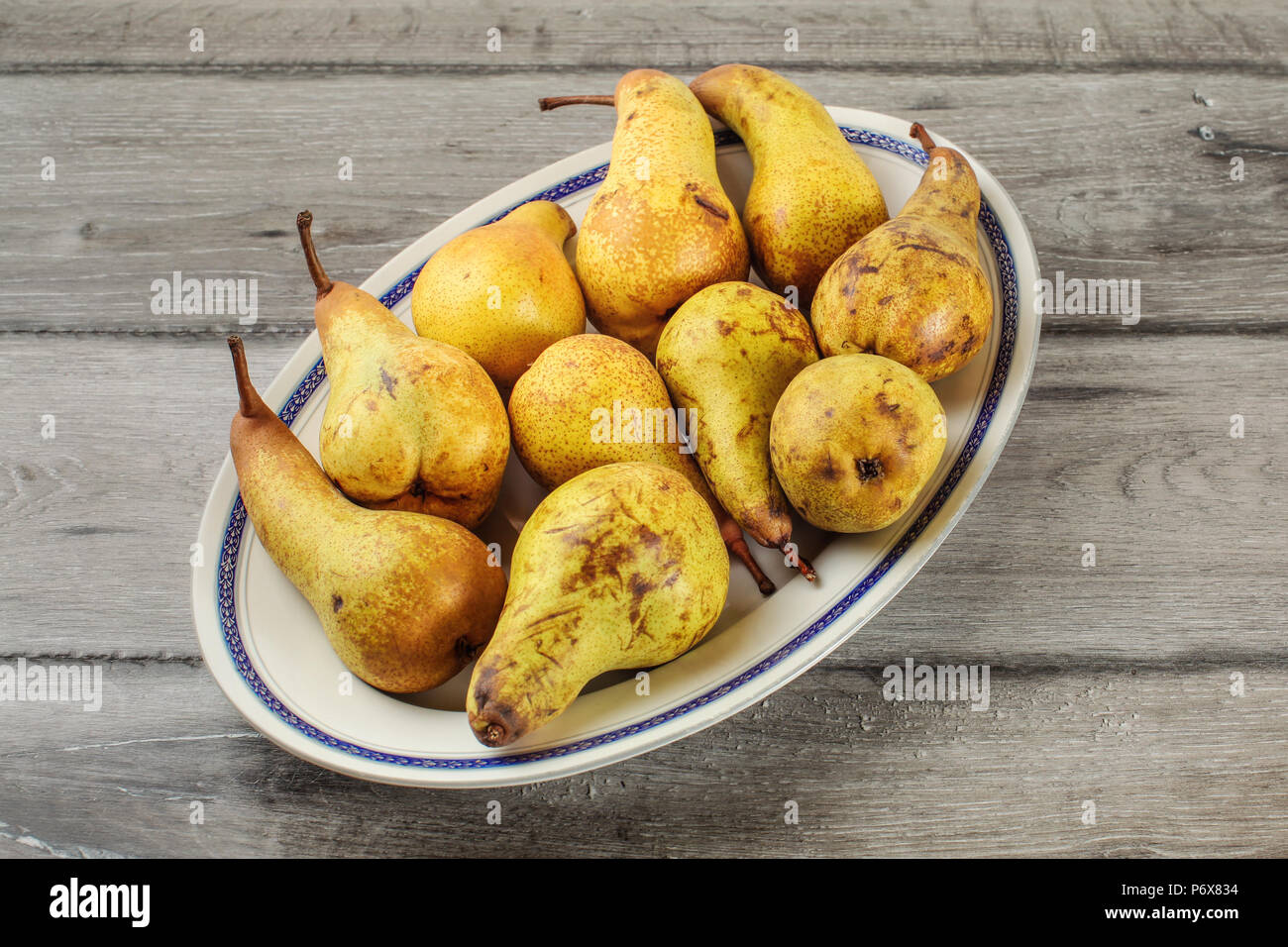 Table top view - oval plate with ripe pears placed on gray wood desk ...