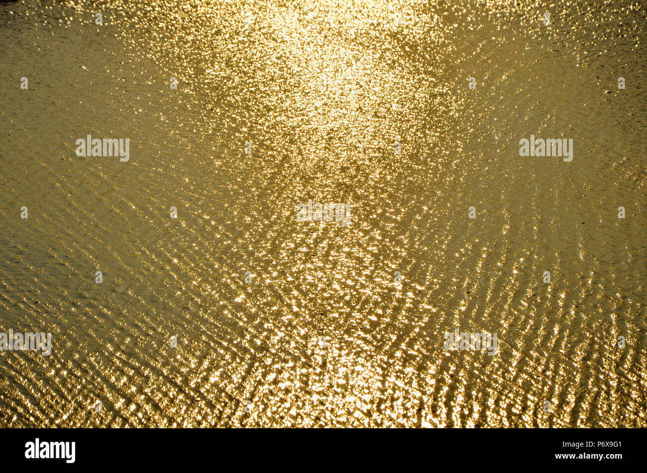 wave of a sandy beach and glare of the sun, golden yellow background ...