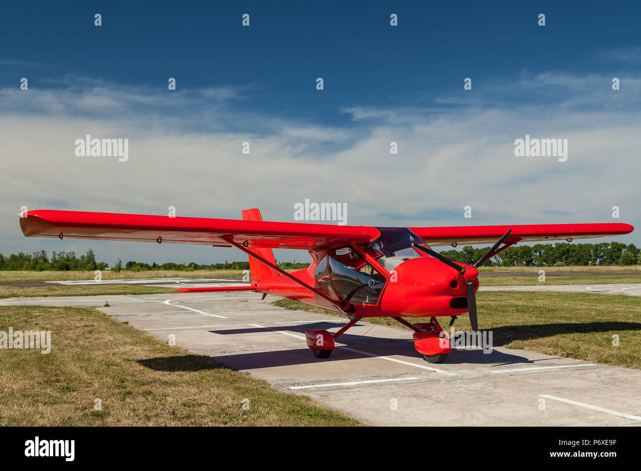 Light aircraft of a red color on a private airfield to prepare for the ...