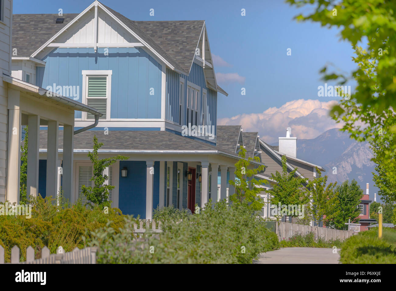 Baby blue house in neighborhood with sidewalk Stock Photo - Alamy
