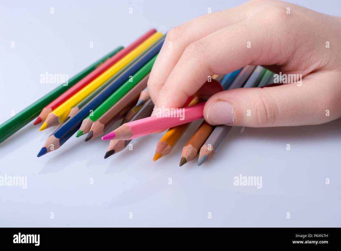 Hand holding color Pencils placed on a white background Stock Photo - Alamy