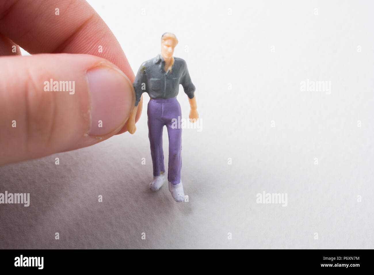 Tiny figurine of man miniature model in hand Stock Photo - Alamy
