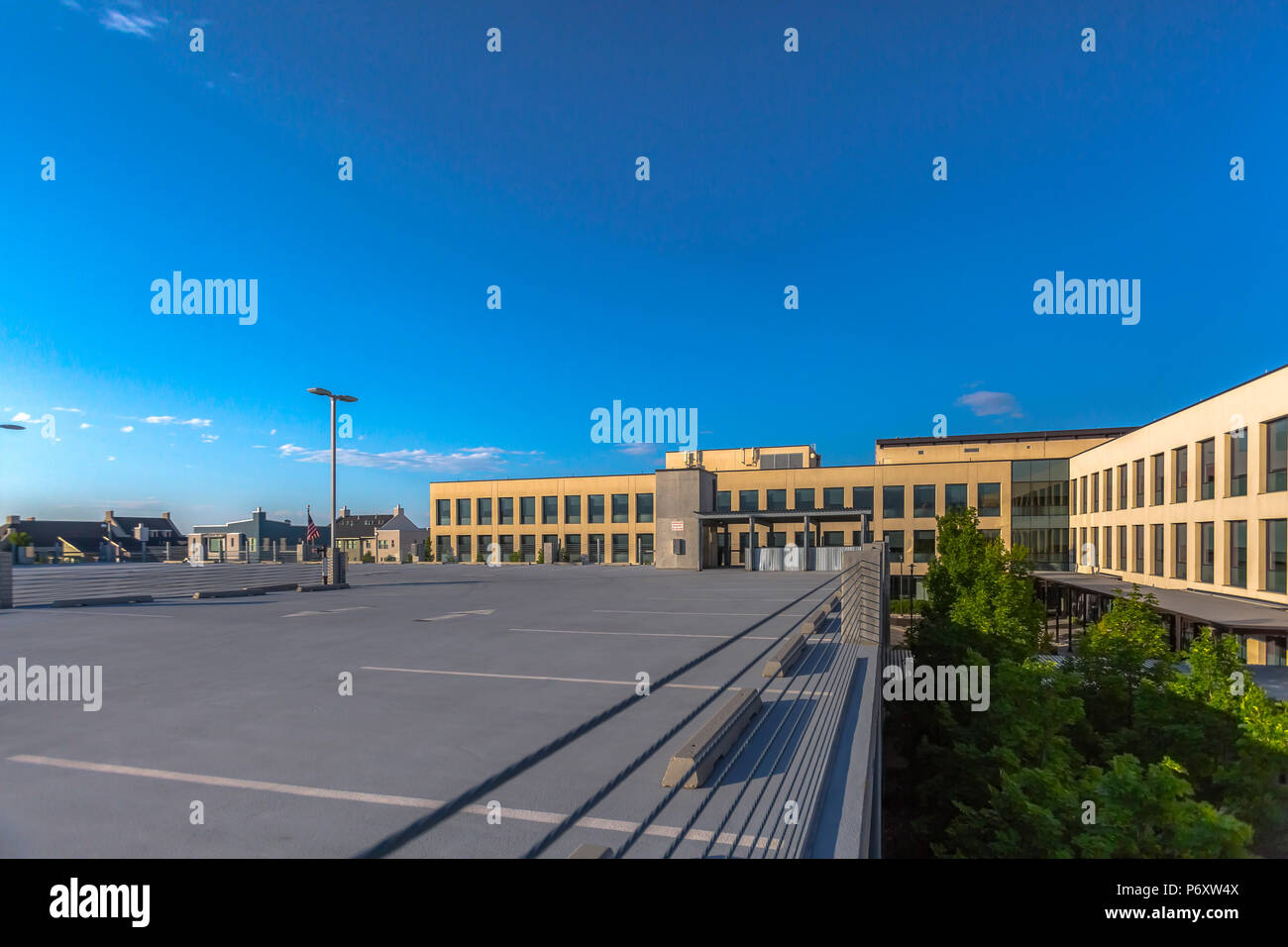 Empty parking lot with trees and office building Stock Photo - Alamy