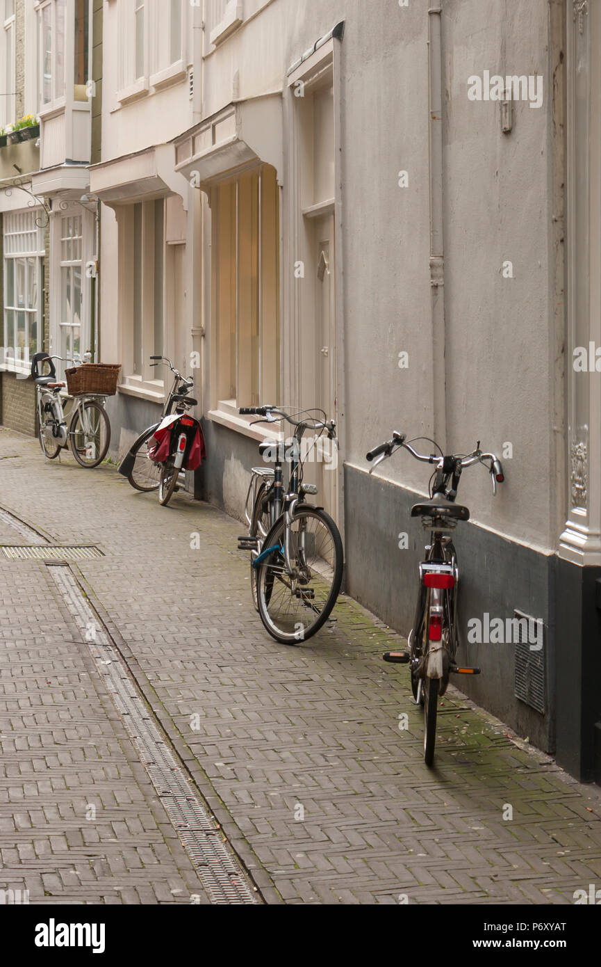 Dutch street scene with bikes resting up in front of townhouses, on an ...