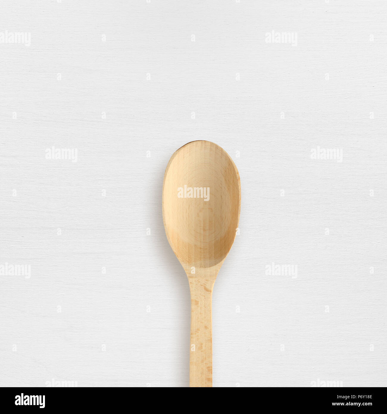 Empty wooden spoon on white table top view Stock Photo - Alamy