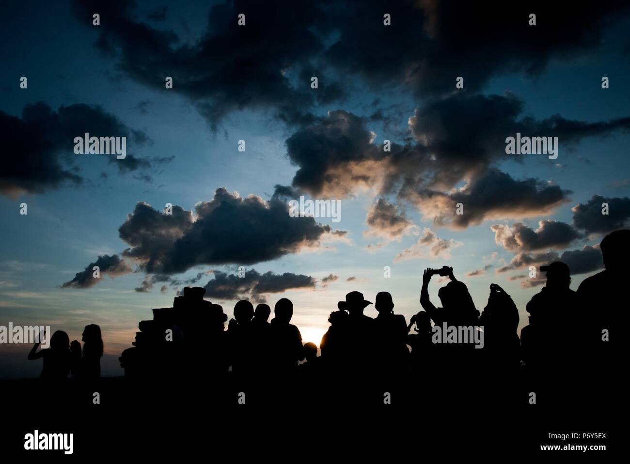 Group of people at sunrise photographing the sun, silhouettes of people ...