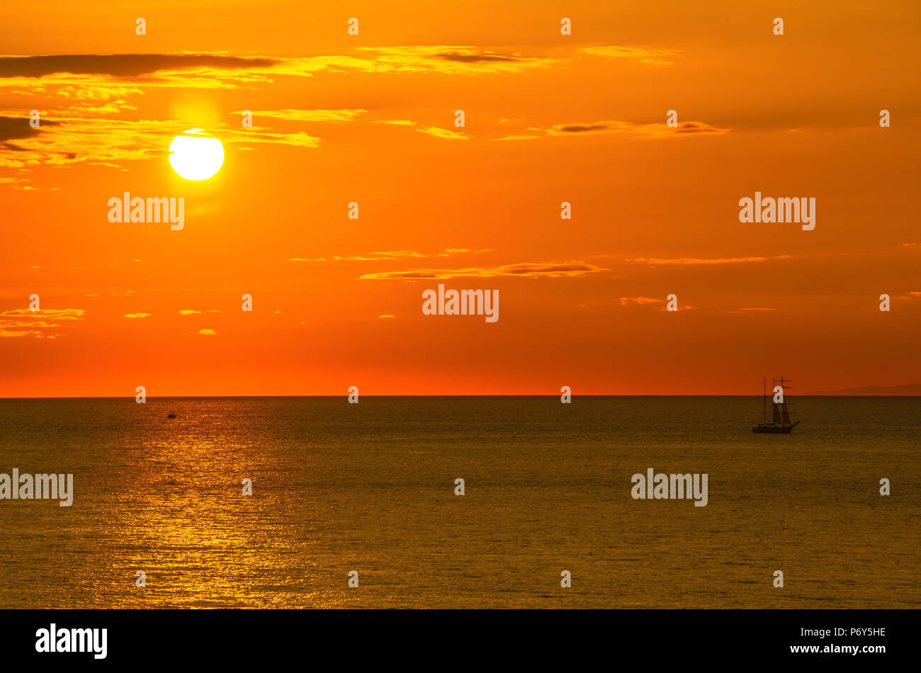Beautiful sunset above the sea and small boat Stock Photo - Alamy