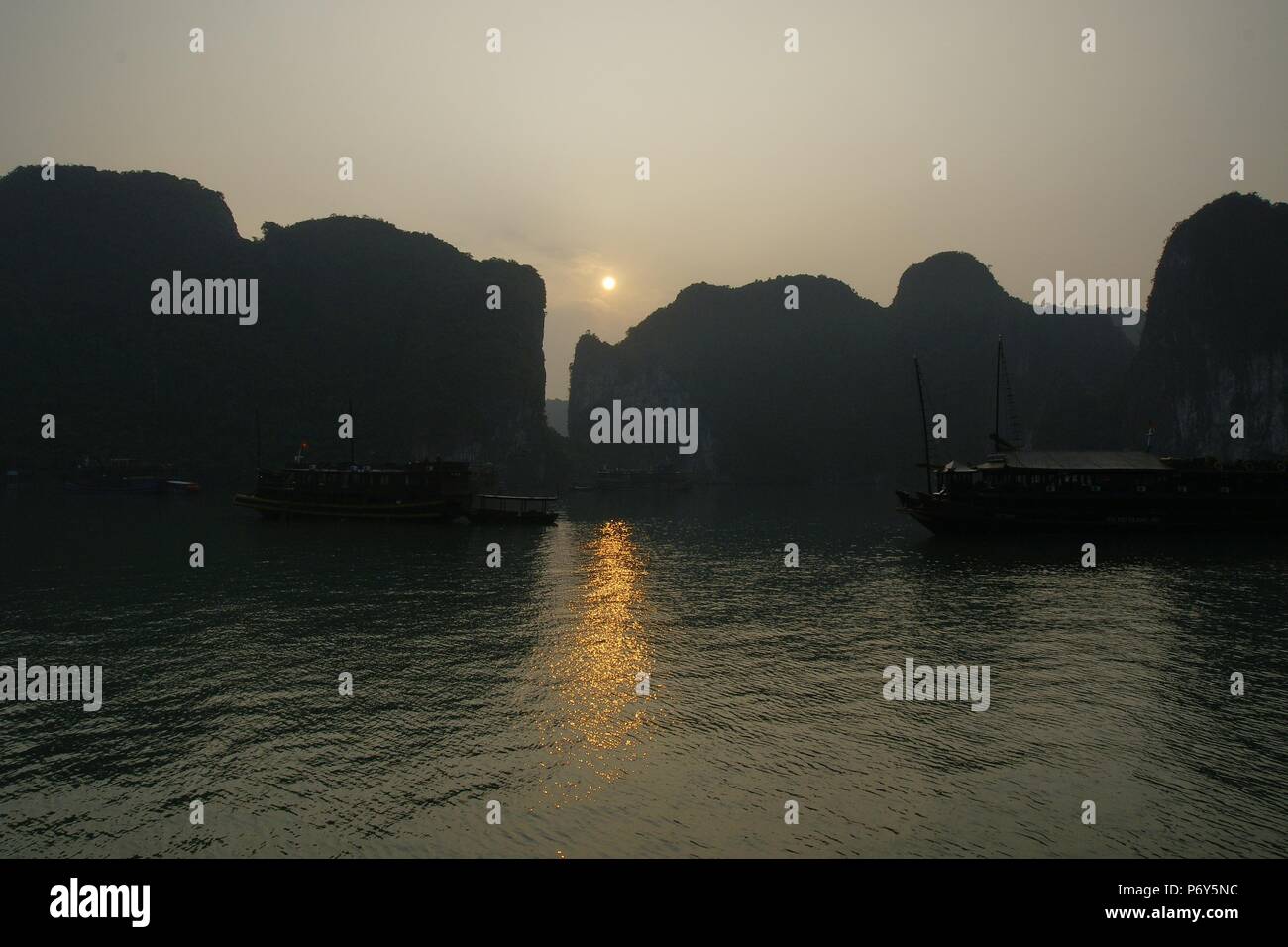 Vietnamese bay with boats plying the sea between mountains and rocks at ...