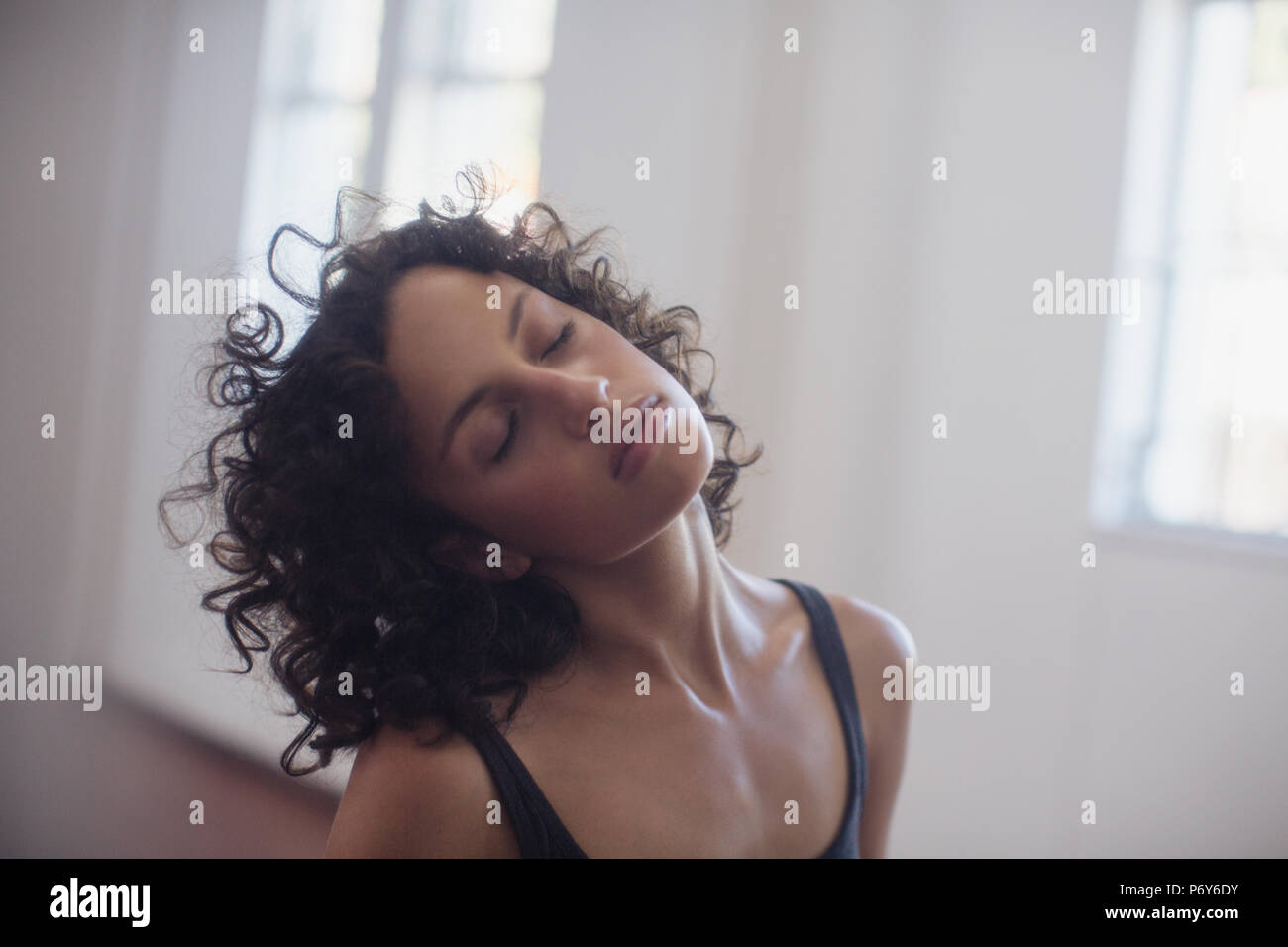 Calm young female dancer stretching neck in dance studio Stock Photo ...