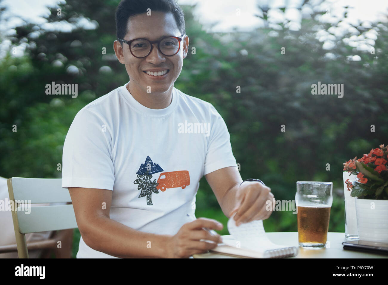 Young spectacled man tearing out pages from notebook Stock Photo - Alamy