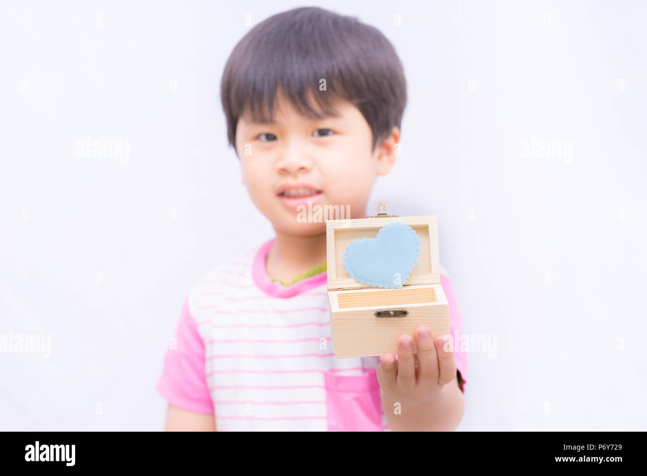 Blue heart in gift box on blurred image cute boy background Stock Photo ...