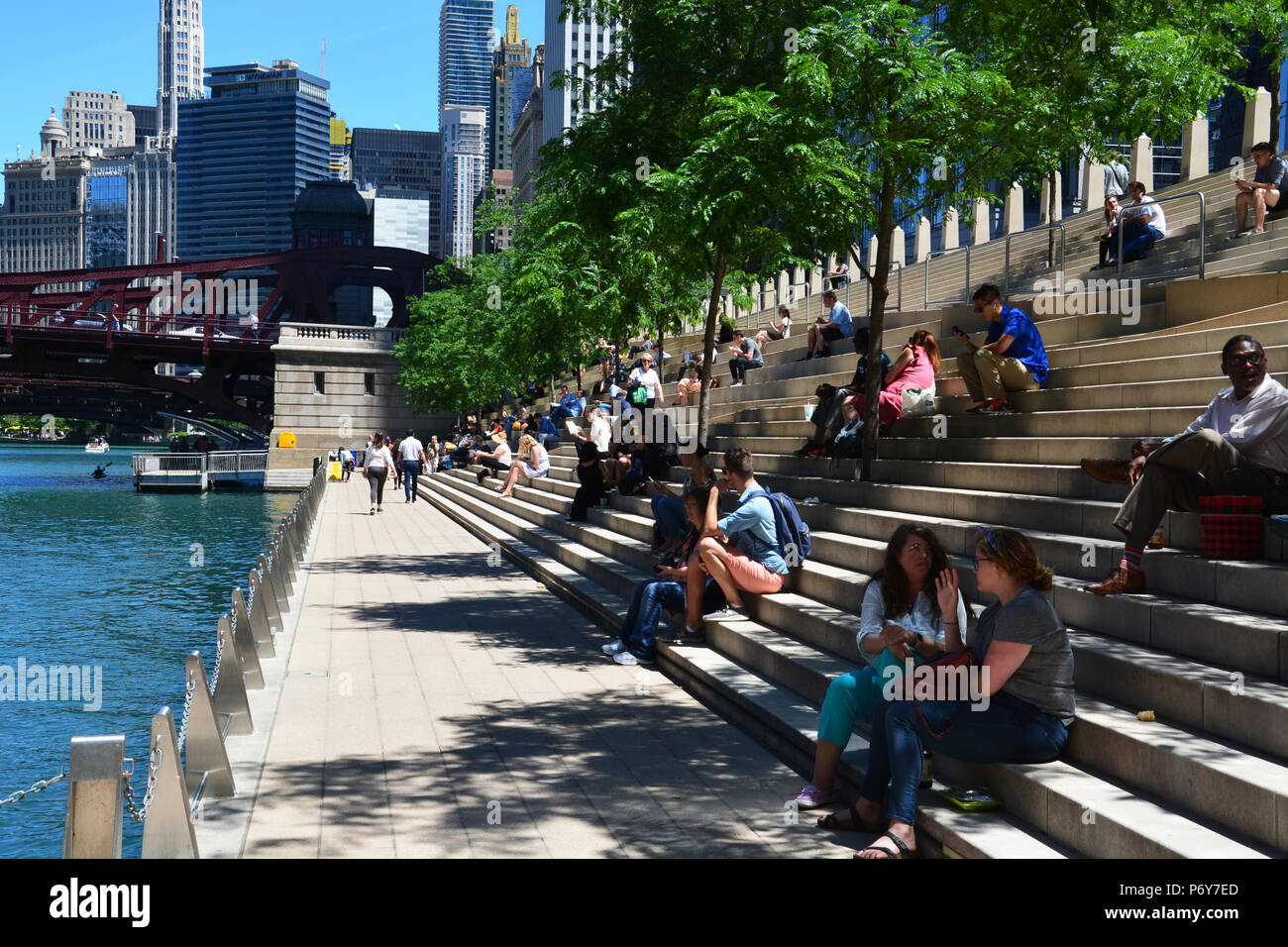 People take a mid day break under the trees on the stadium steps of the ...