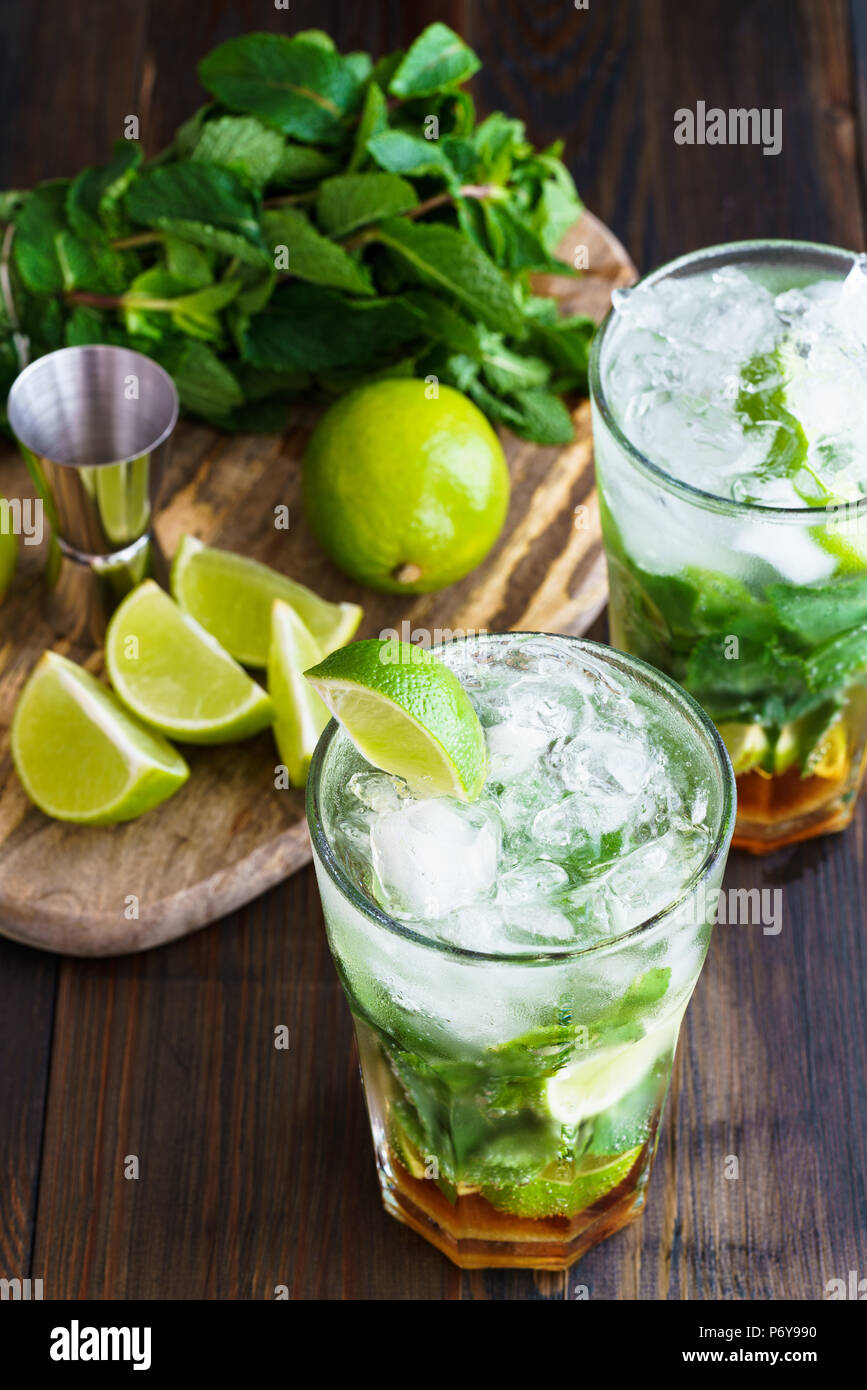 Dirty mojito and ingredients (fresh mint, sliced lime) served on a dark ...