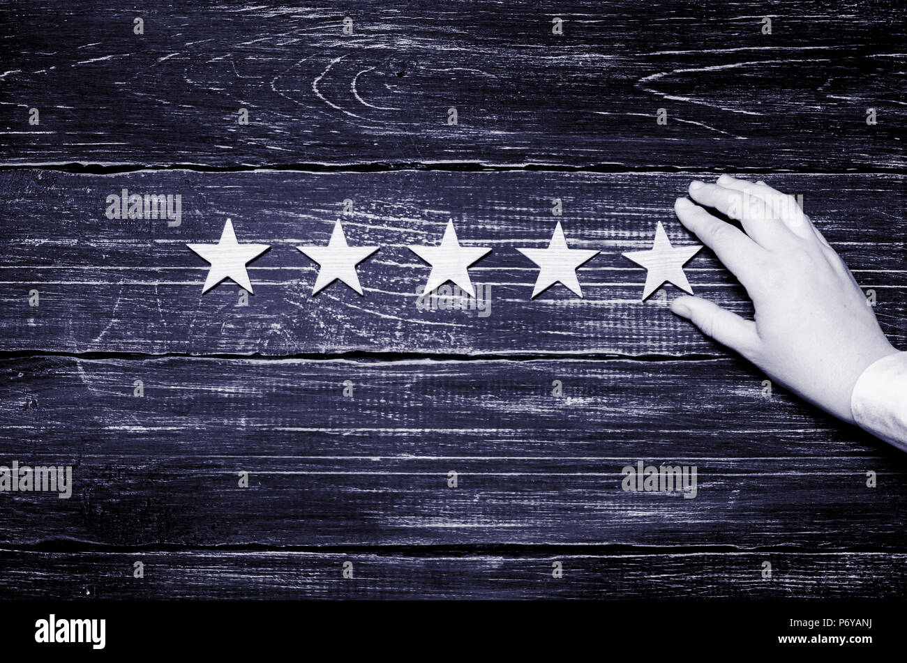 A woman's hand puts the fifth star. Quality status is five stars. A new ...