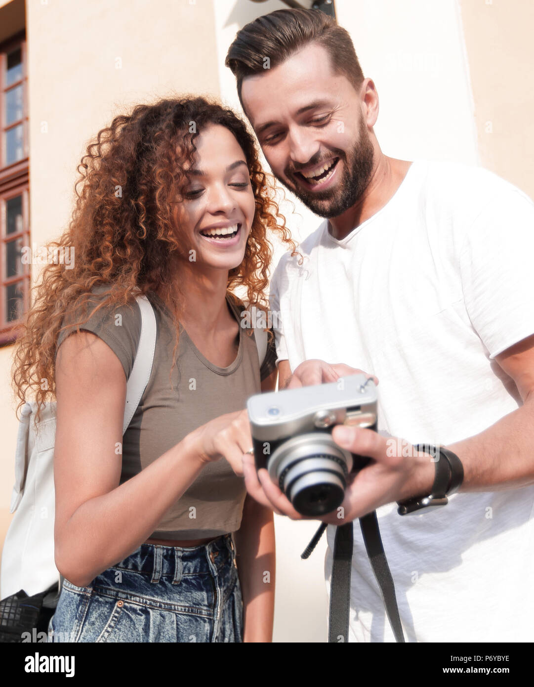 Portrait of young friends walking looking at the photos Stock Photo - Alamy