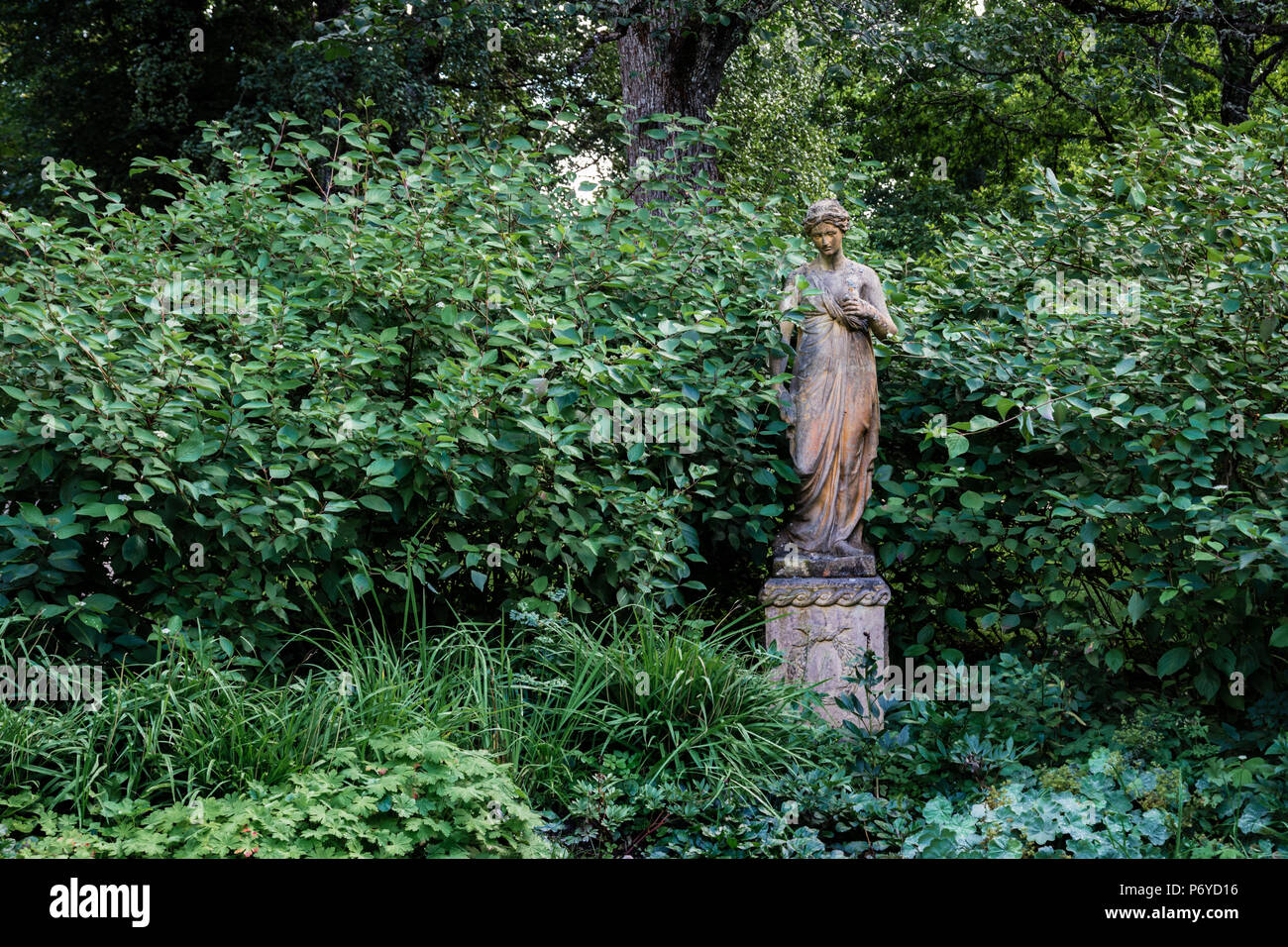 Old greco-roman style statue in garden Stock Photo - Alamy