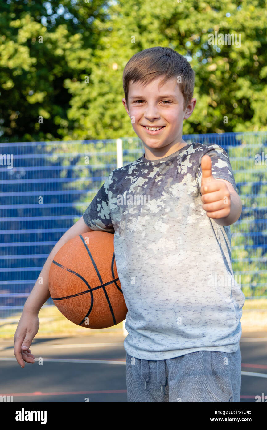 Boy holding basketball in court hi-res stock photography and images - Alamy