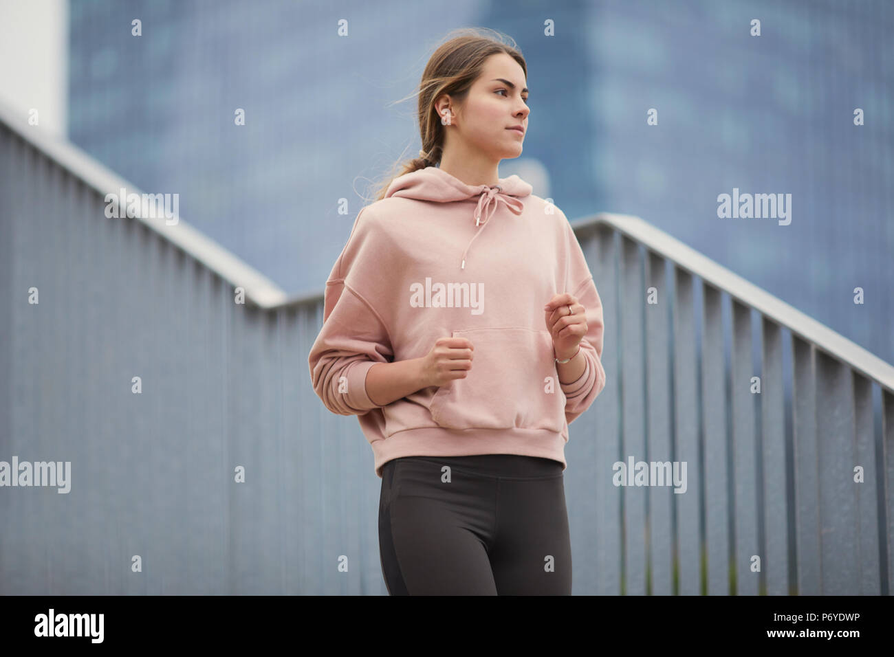 Fit pretty girl running up stairs with city background Stock Photo - Alamy