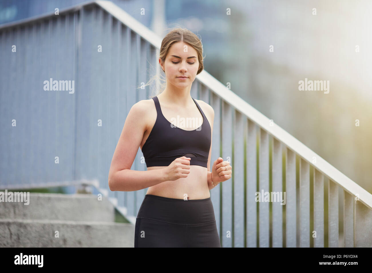 Fit pretty girl running up stairs with city background Stock Photo - Alamy