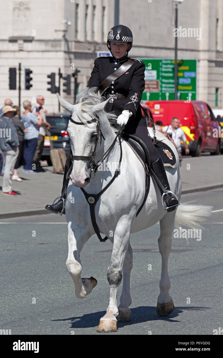 Female UK Police officer riding a white horse Stock Photo - Alamy