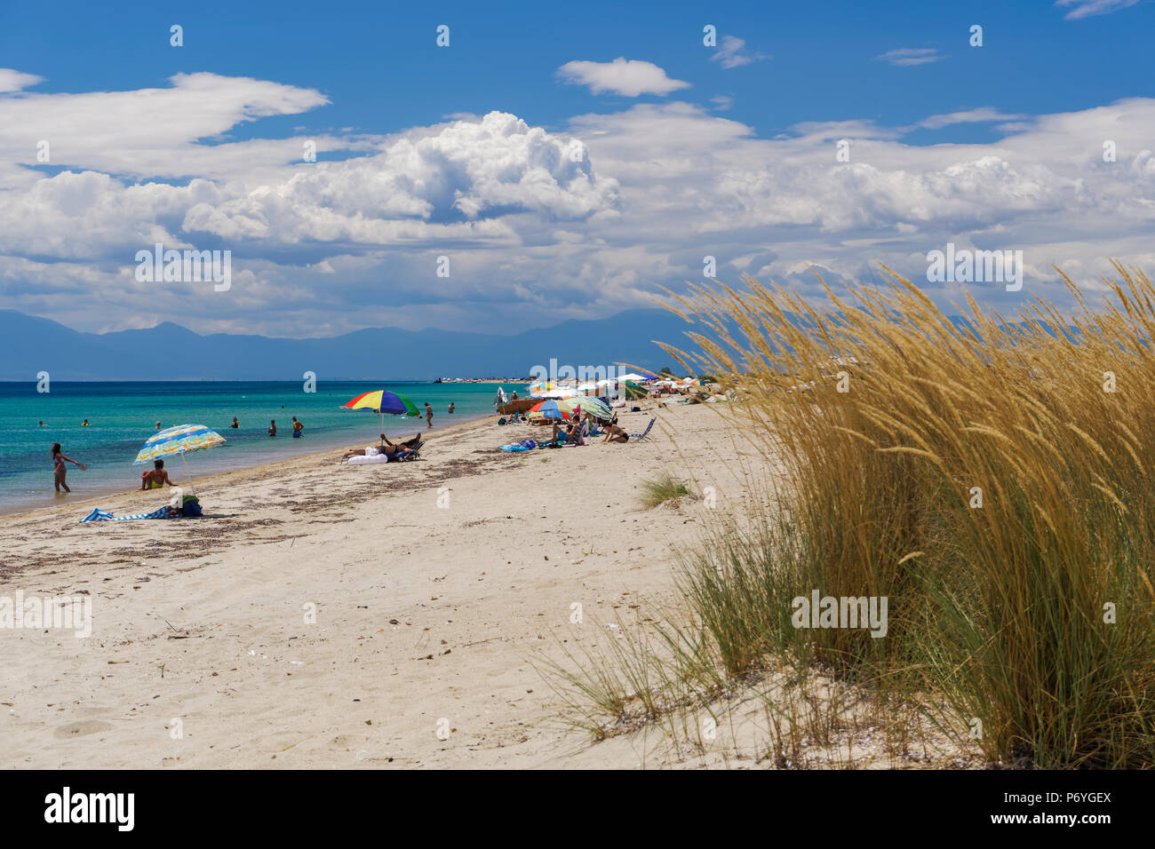 Greek Mediterranean beach with crowd. Bathers with sun umbrellas at a ...
