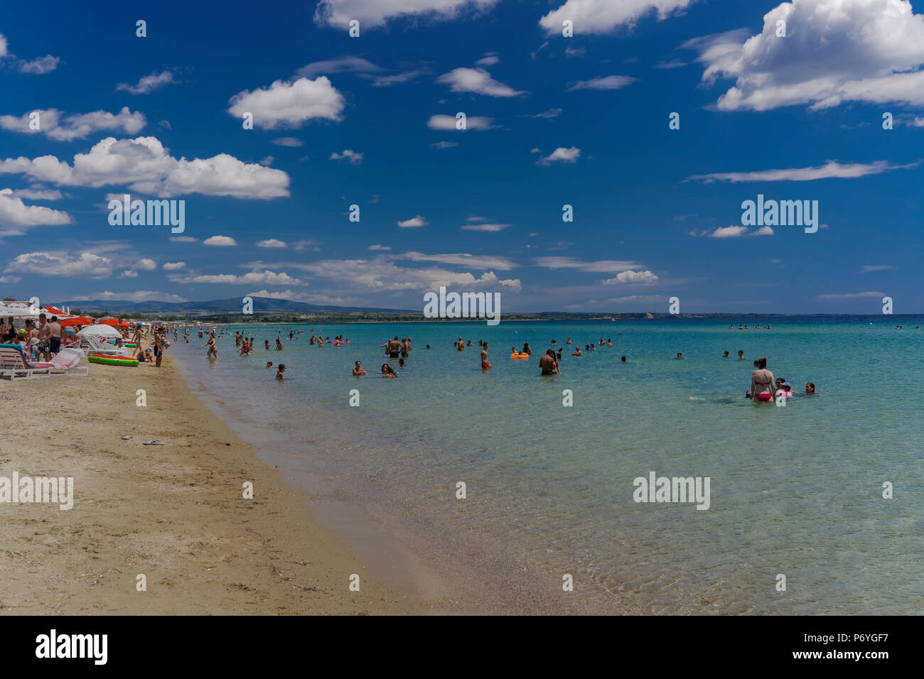 Greek Mediterranean beach bar with crowd. Bathers with sun umbrellas at ...