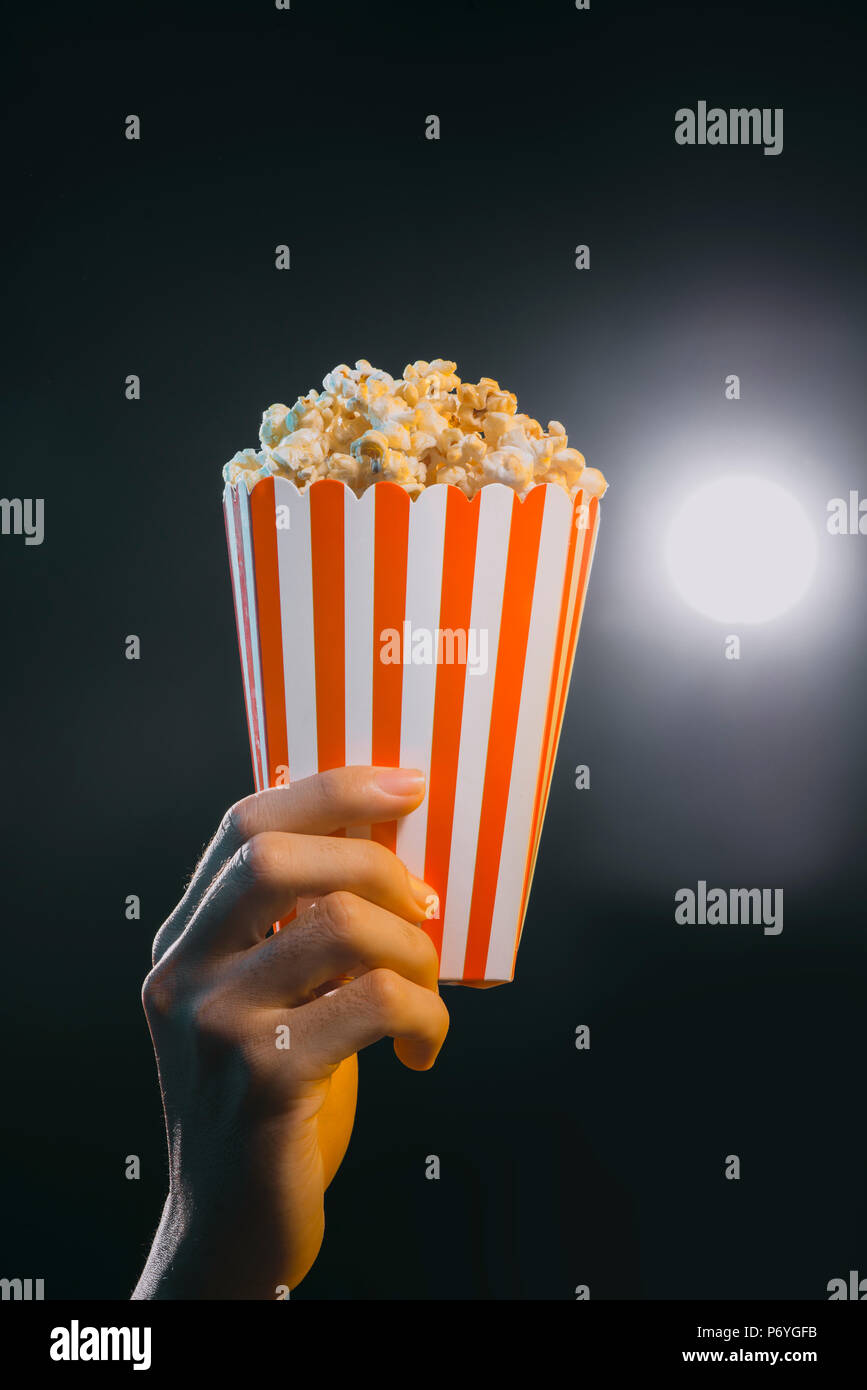 hand holding Popcorn in striped bucket isolated at the movie Stock ...