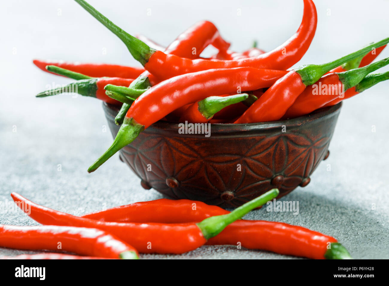 Red hot chili pepper pod close - up on grey concrete background ...