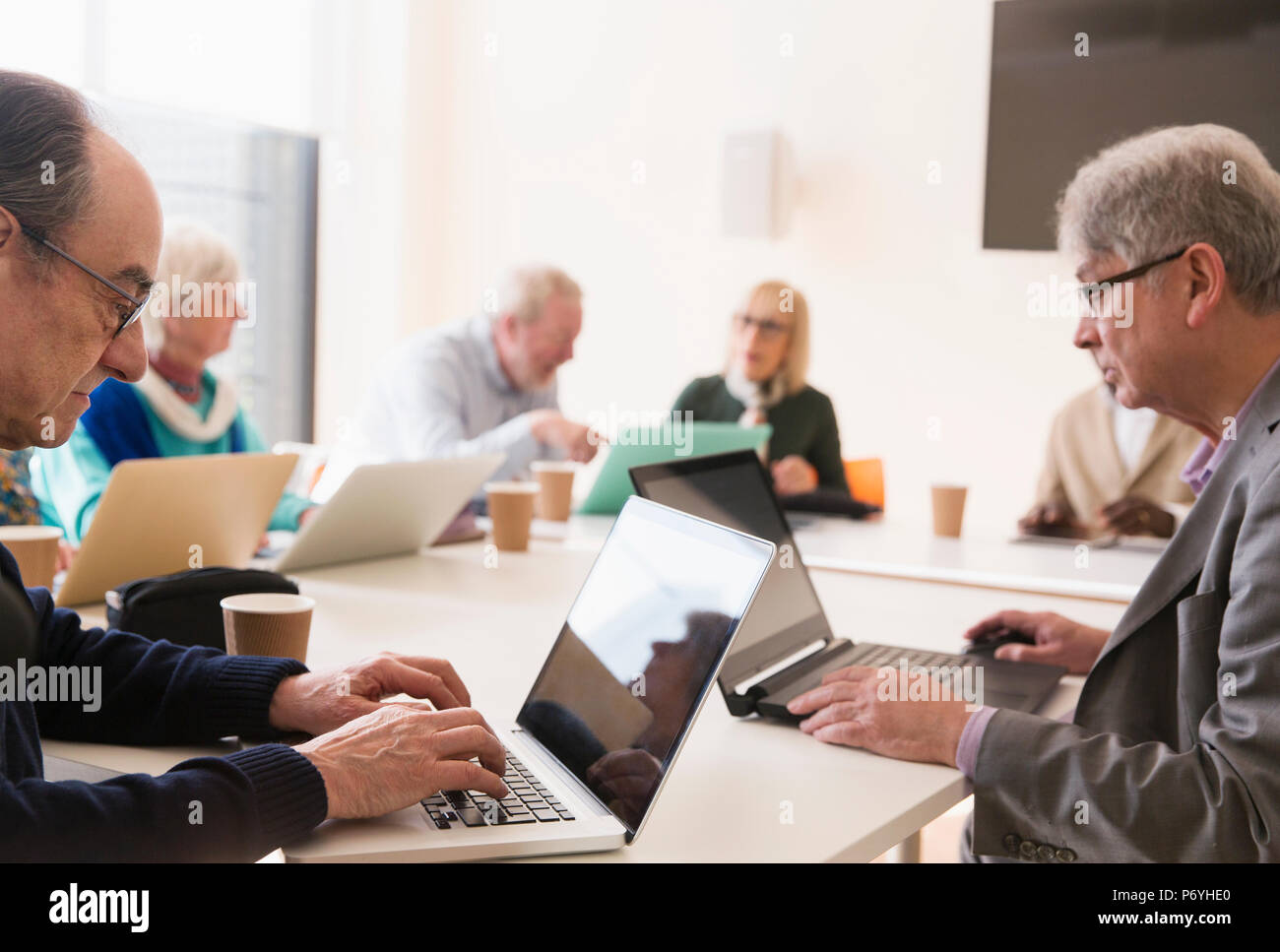 Senior businessmen using laptops in conference room meeting Stock Photo ...