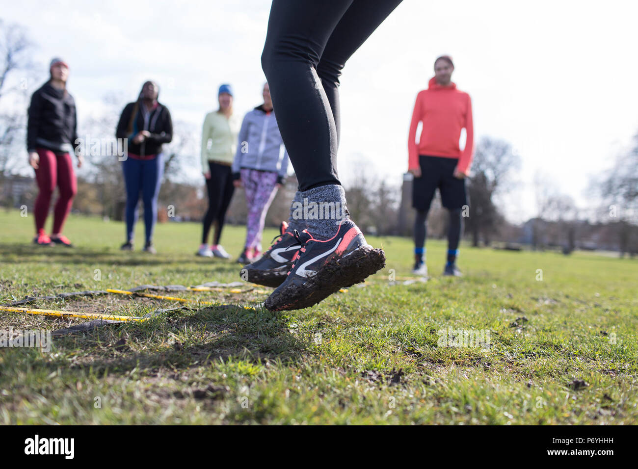 Woman doing speed ladder drill in sunny park Stock Photo - Alamy