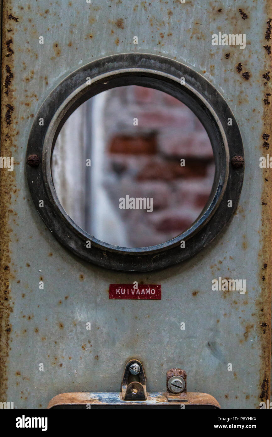 Small glass window in rusty metal wall with view to brick wall Stock ...
