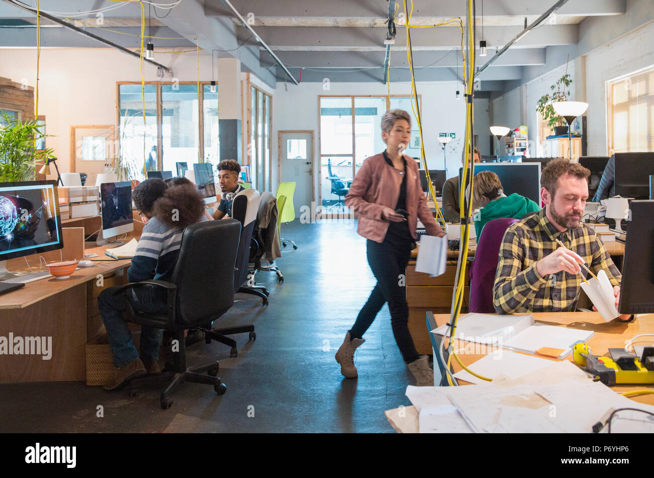 Creative business people working in open plan office Stock Photo - Alamy