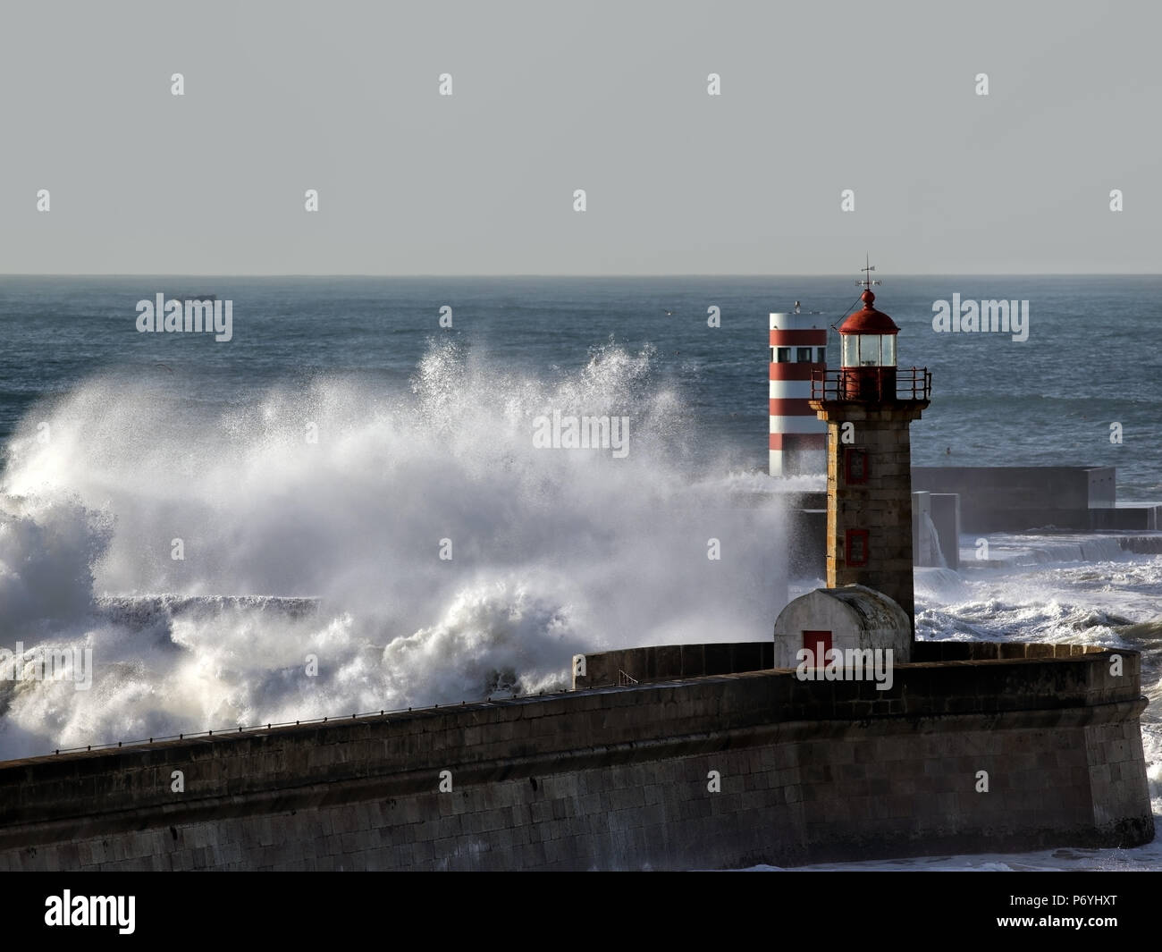 Big splashing waves with spray over piers and beacons of Douro river ...