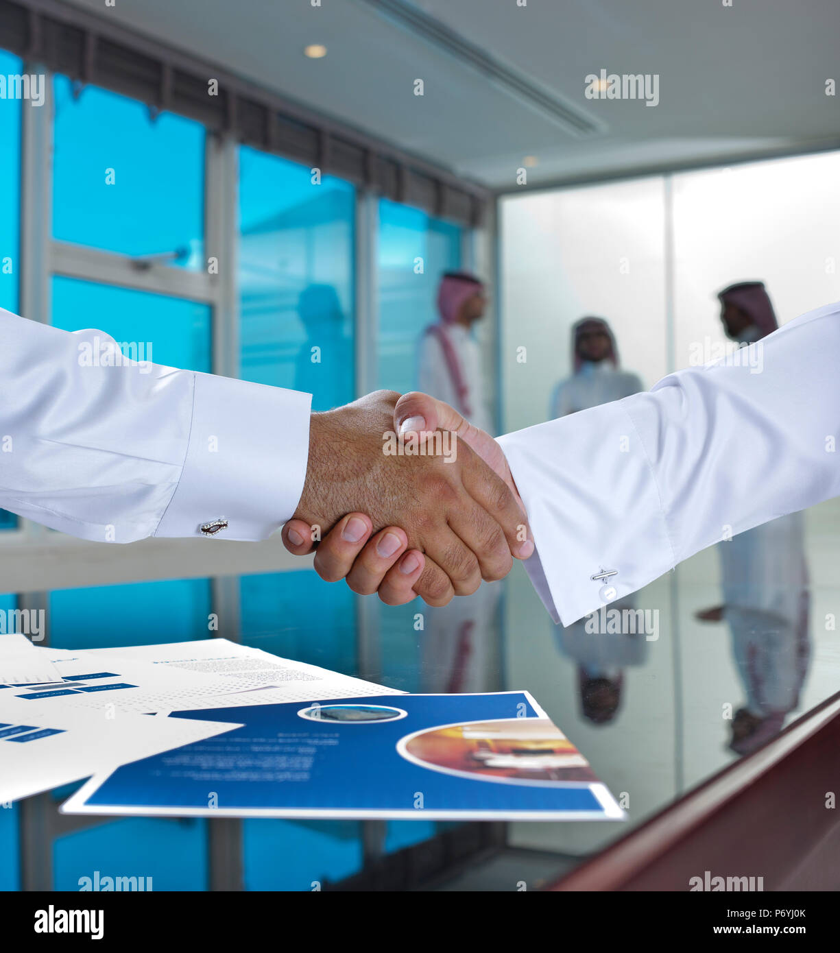 Saudi Arab businessmen shaking hands, and making agreement or a deal in ...