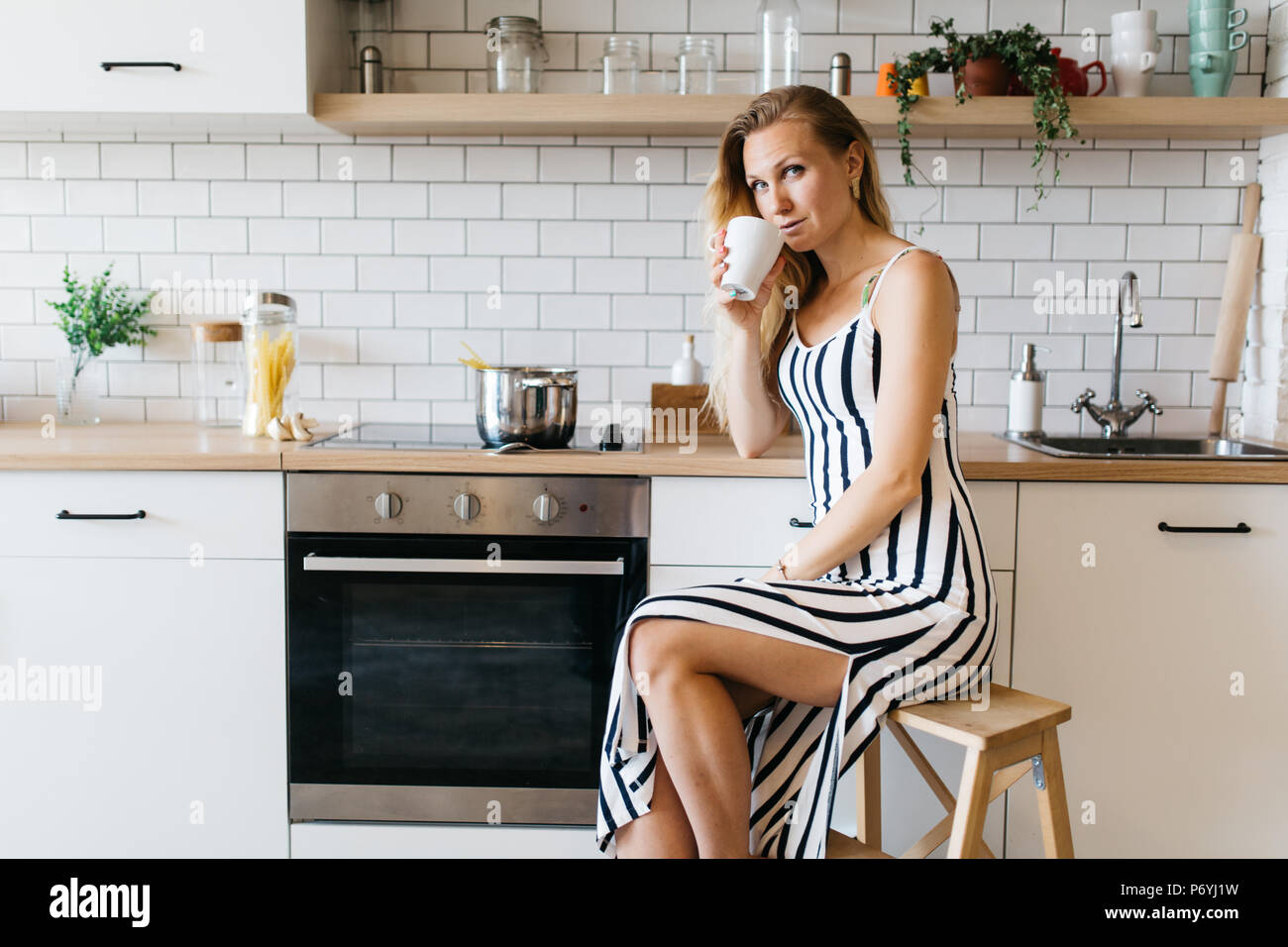 Photo of beautiful woman in long striped dress in kitchen Stock Photo ...