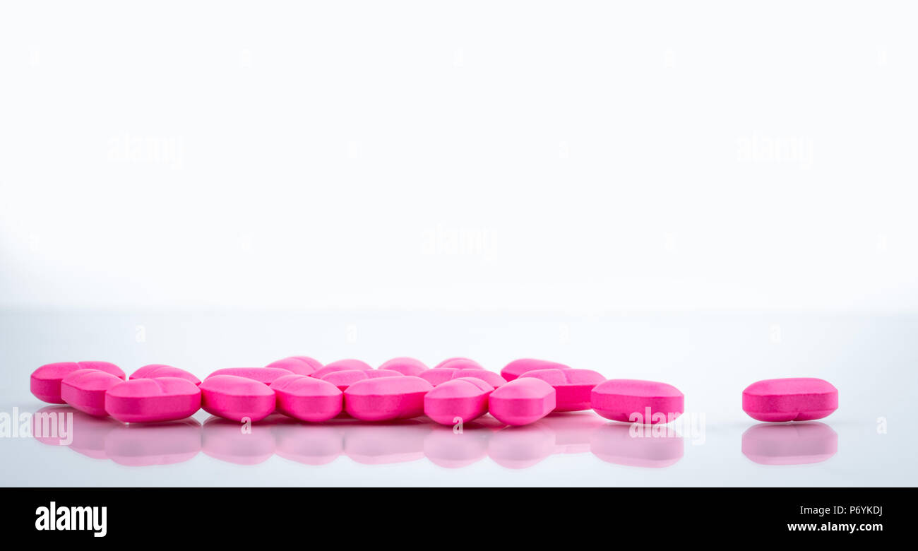 Pile of pink tablets pill isolated on white background. Norfloxacin 400 ...