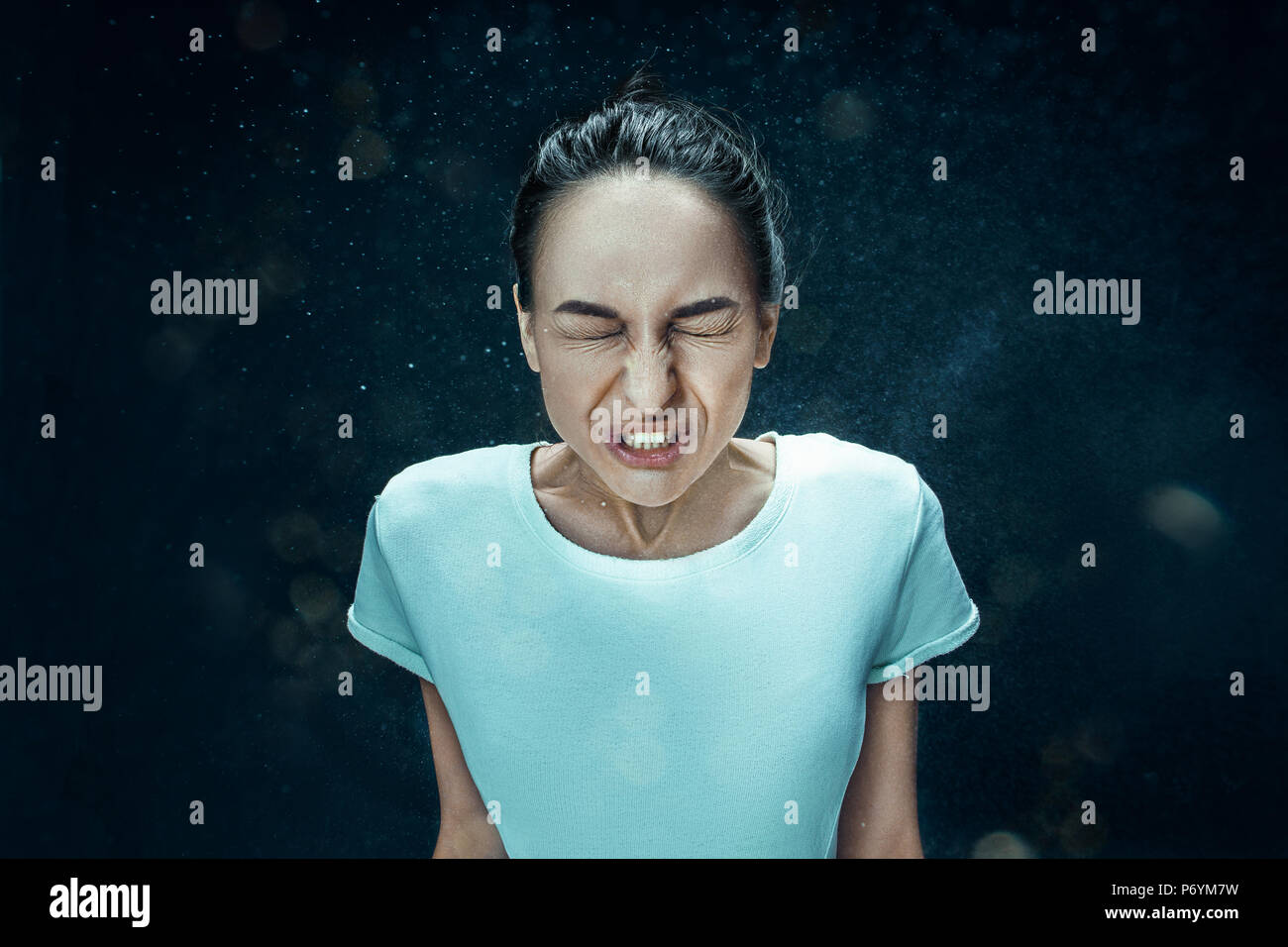 Young woman sneezing, studio portrait Stock Photo - Alamy
