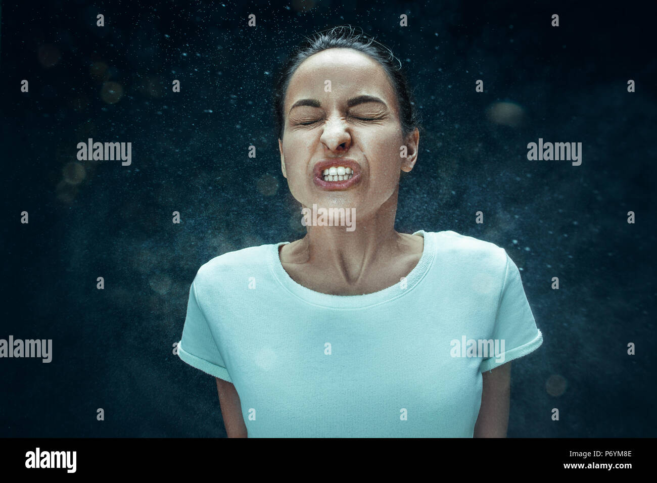 Young woman sneezing, studio portrait Stock Photo - Alamy