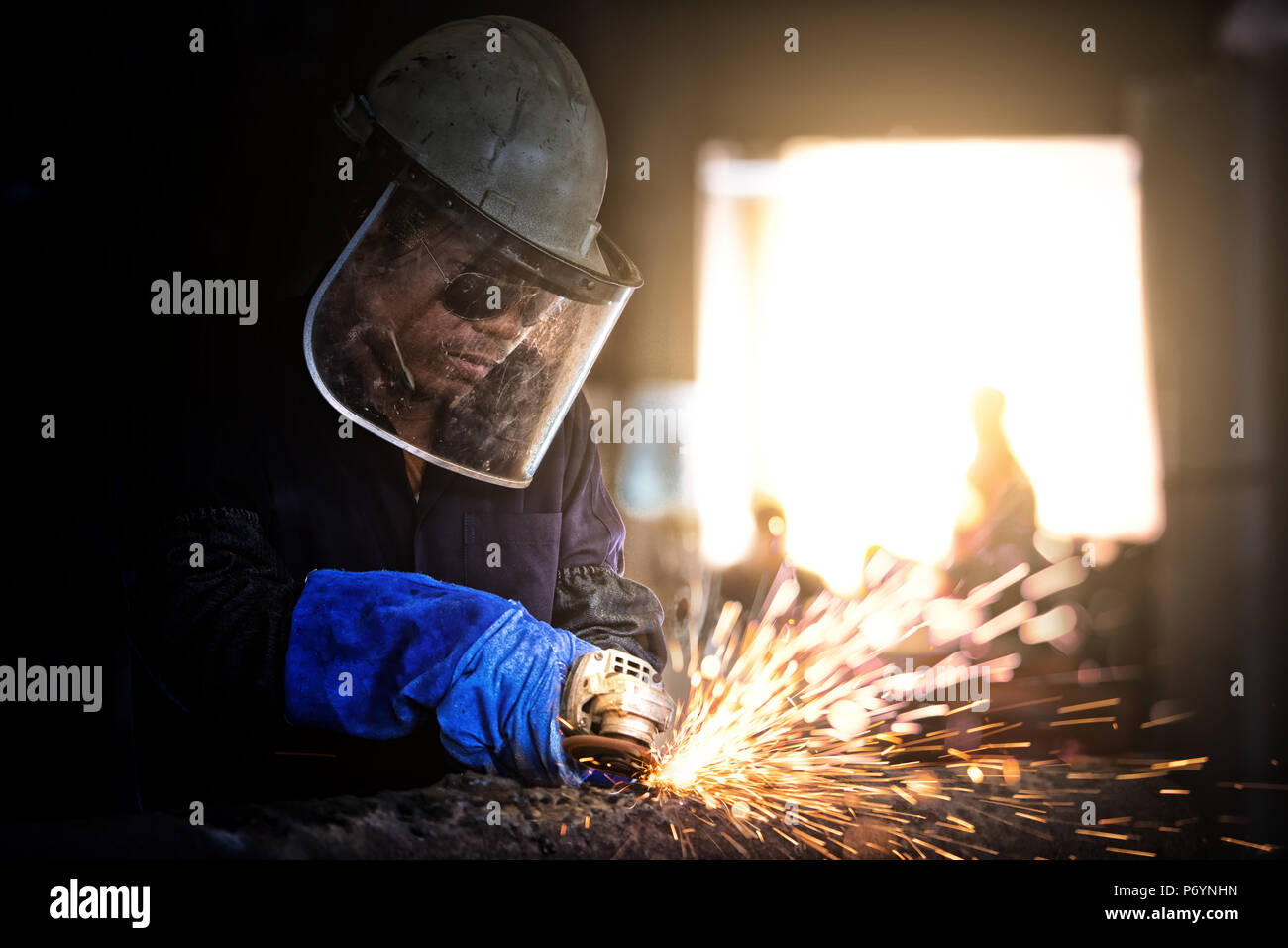 Electric wheel grinding on steel structure in factory.Handyman with ...