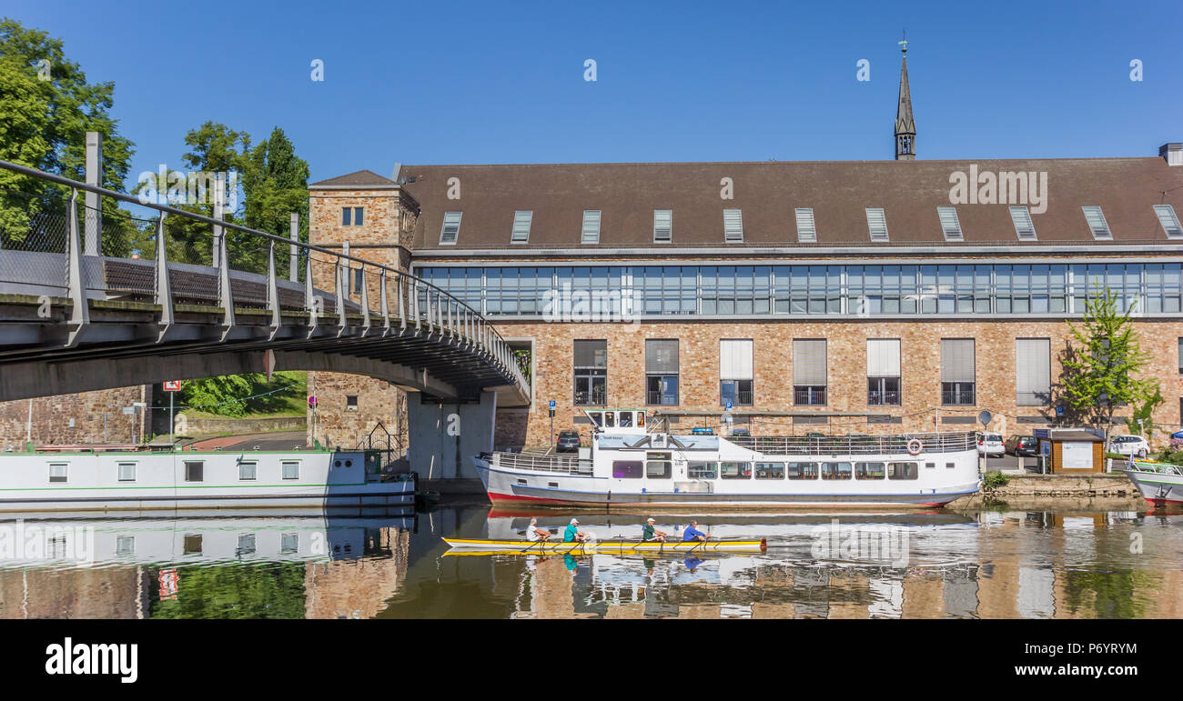 Panorama of a rowing boat going under a bridge at the fulda river in ...