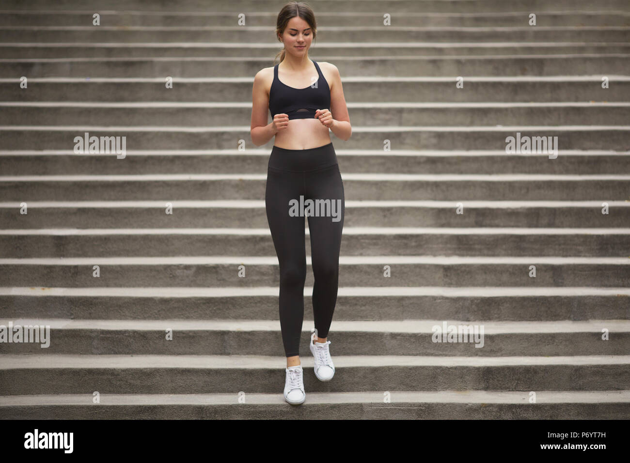 Fit pretty girl running up stairs with city background Stock Photo - Alamy